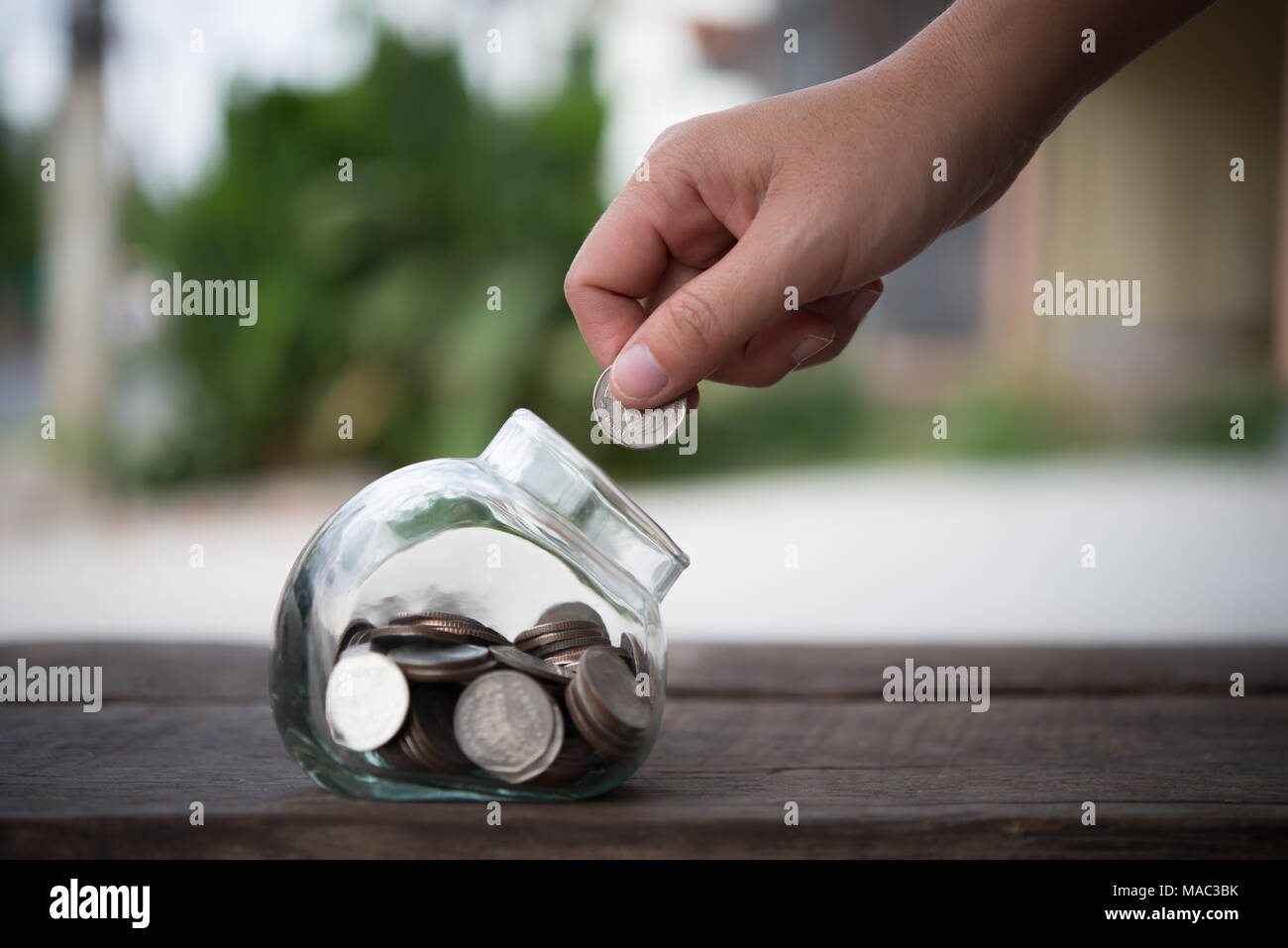 Hands dropping coins hi-res stock photography and images - Alamy