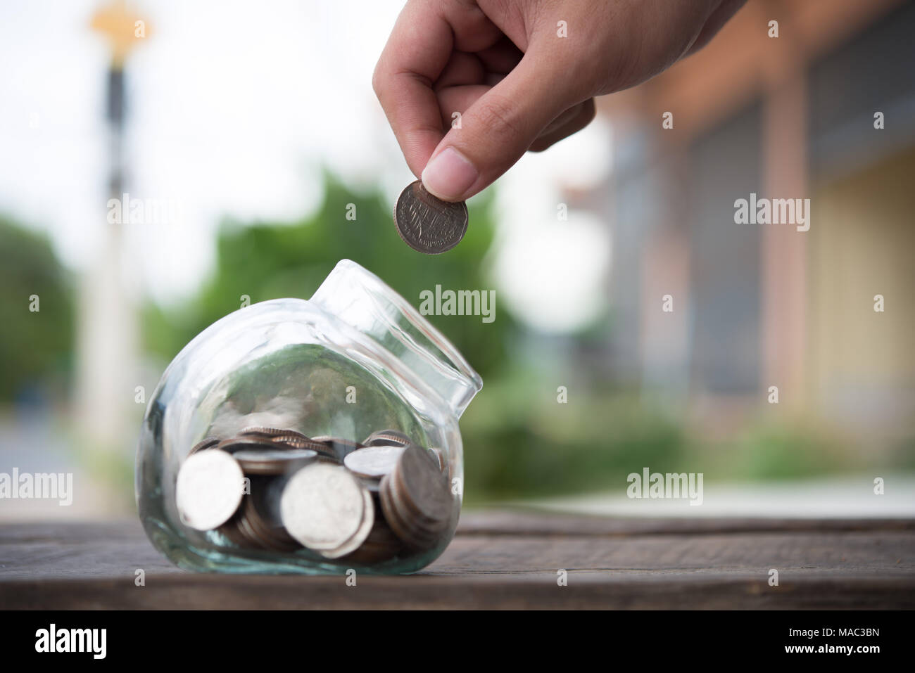 Hands dropping coins hi-res stock photography and images - Alamy