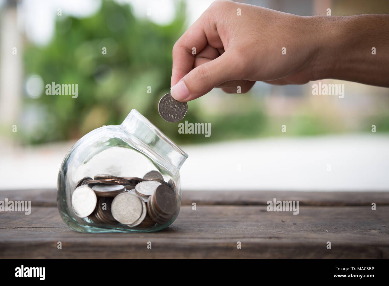 Man hands saving money into bottle for cash in future investment Stock ...