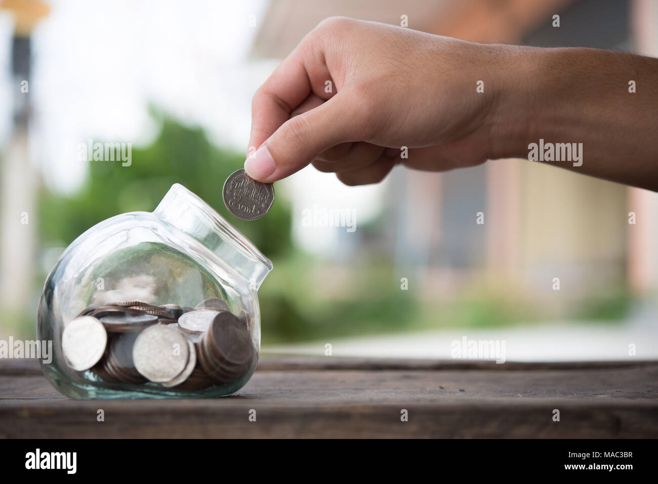 Man hands saving money into bottle for cash in future investment Stock ...