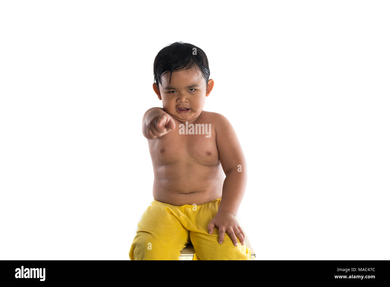 Little Asian Boy with angry confused expression on face sitting ...