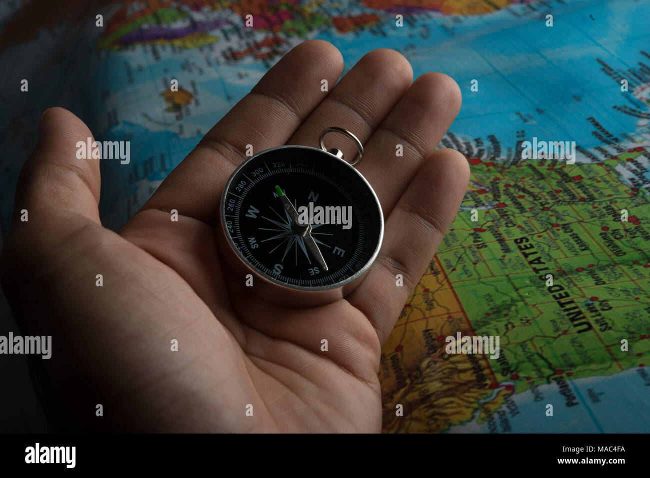 Man hand holding compass on top of a map Stock Photo - Alamy