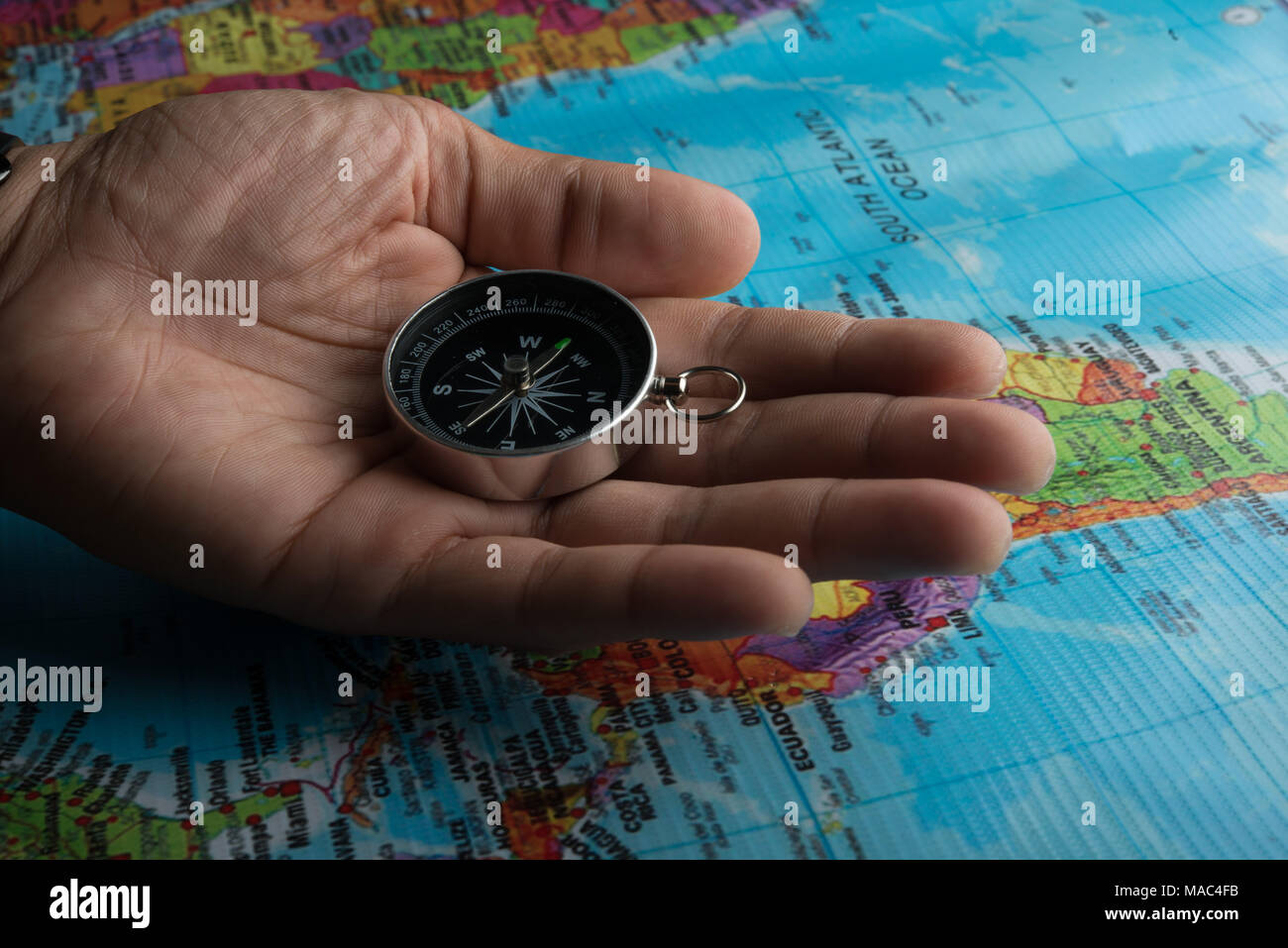 Man hand holding compass on top of a map Stock Photo - Alamy