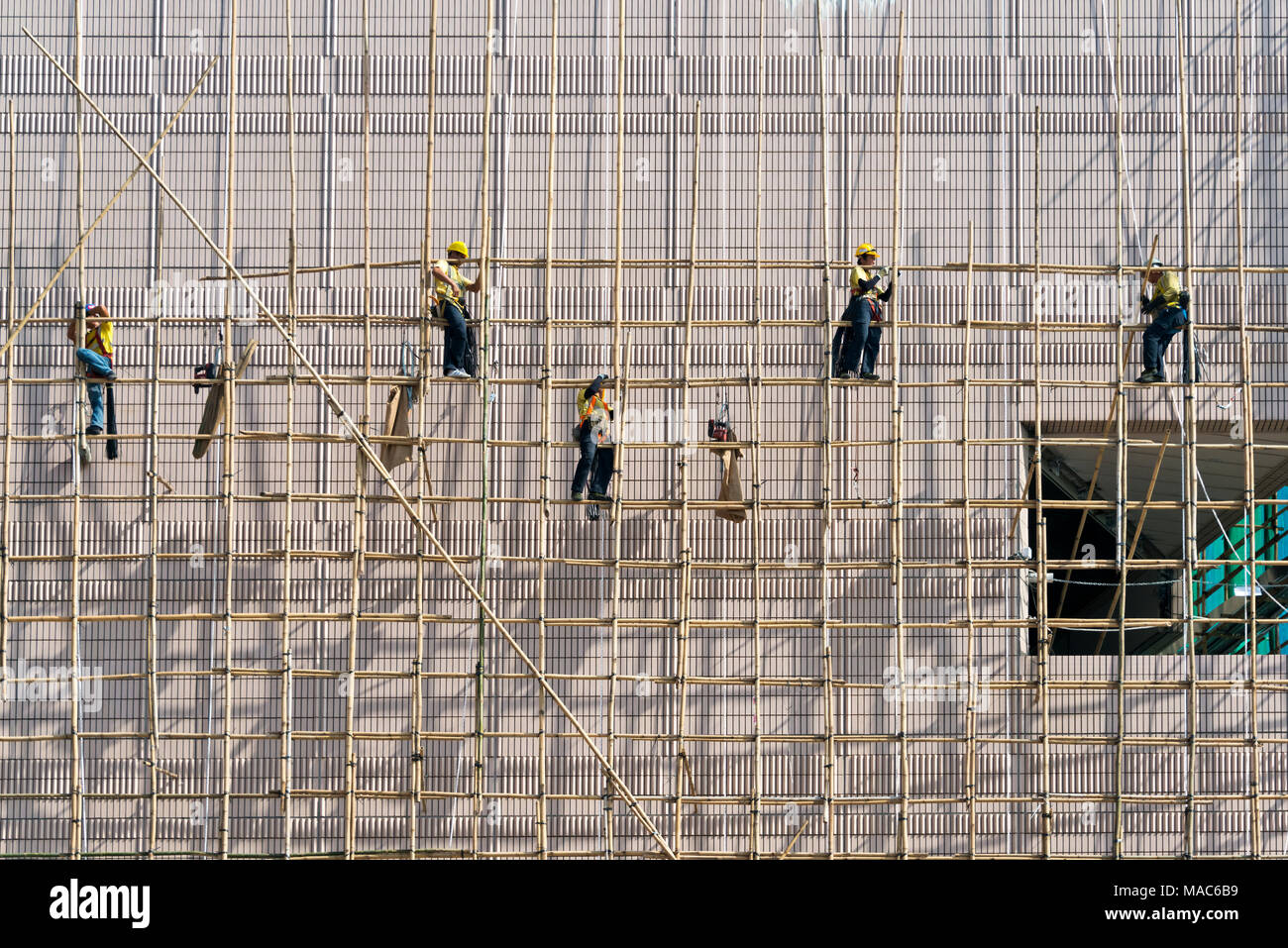 Construction workers on scaffolding outside a new construction, Hong ...