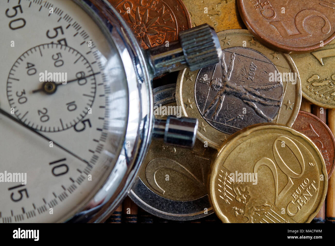 Stopwatch and pile of coins on wooden table background Stock Photo - Alamy