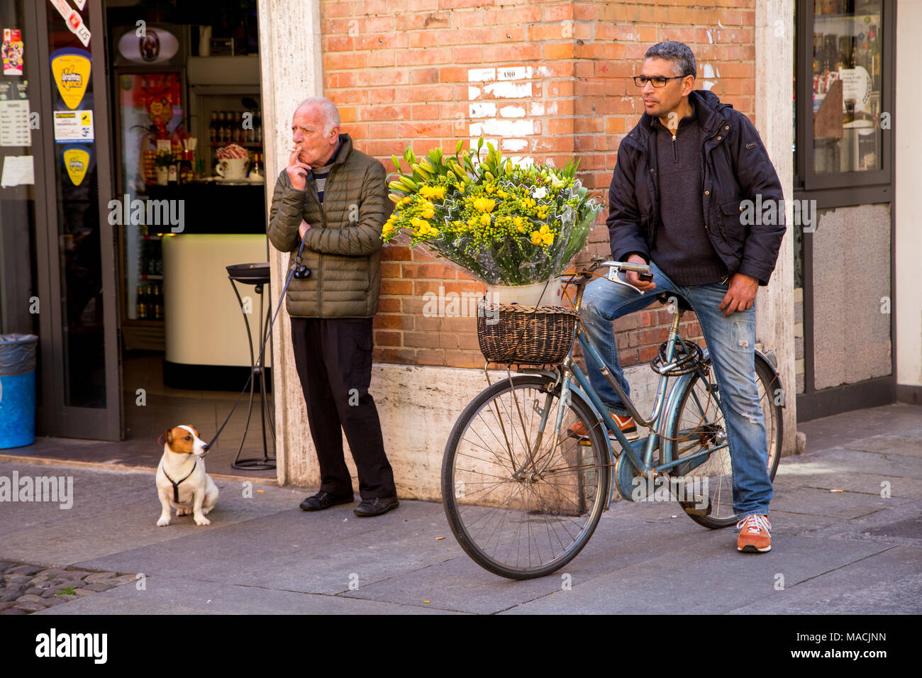 Street scene in Modena Italy showing a man with a dog and a man on his ...