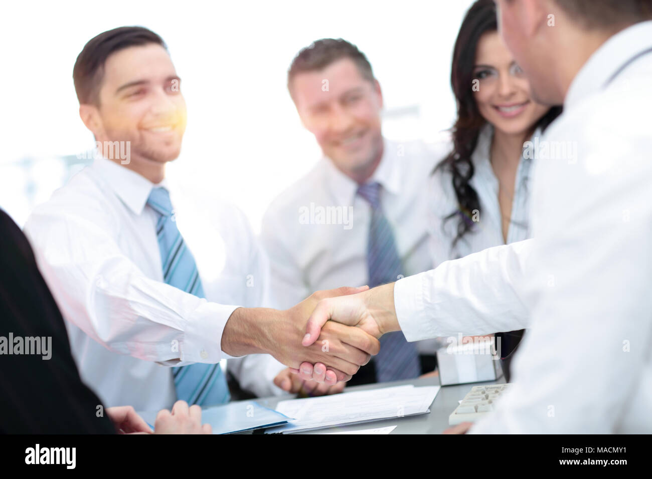 Two handsome men shaking hands with smile while sitting on the c Stock ...