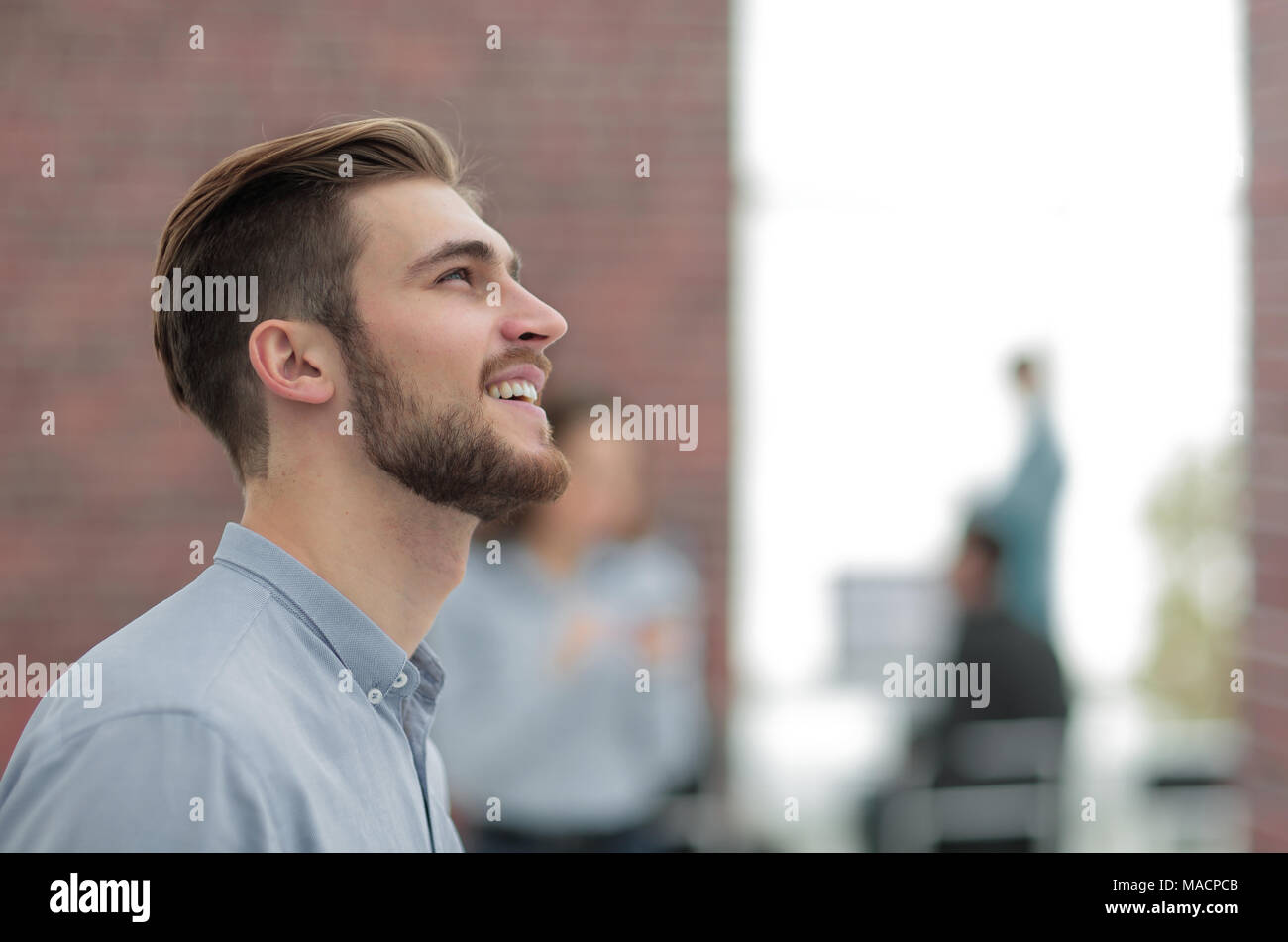 Smiling businessman in profile on office background Stock Photo - Alamy