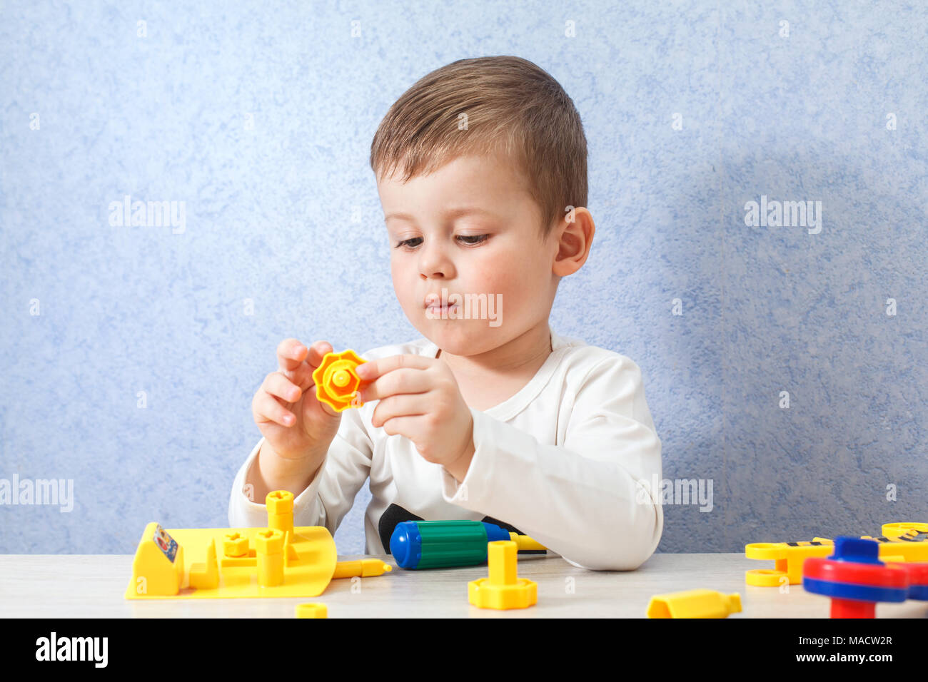 Cute little boy is playing with tools. A toddler working with toy tools ...
