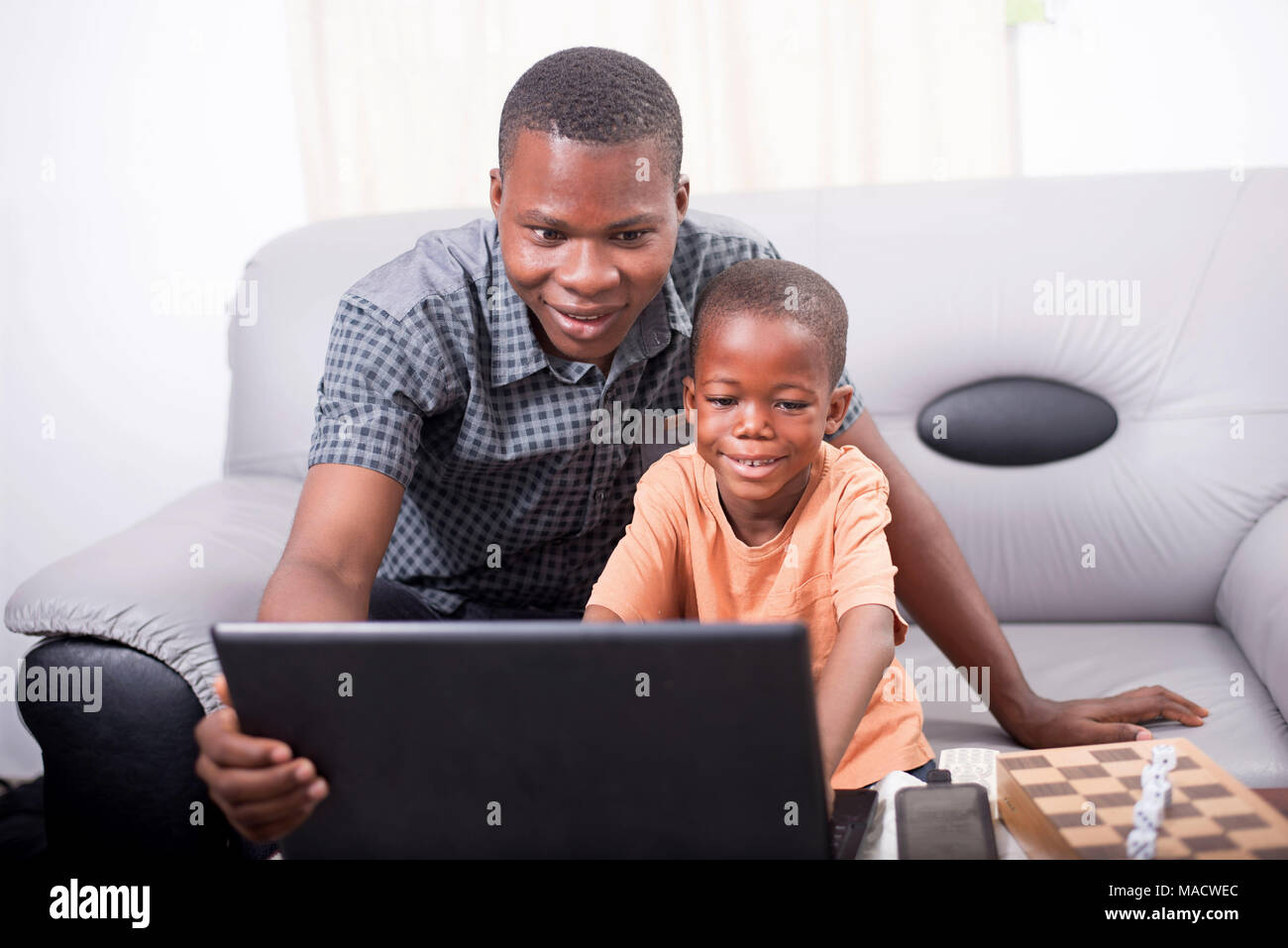 Happy father teaching his son how to work with a computer Stock Photo ...