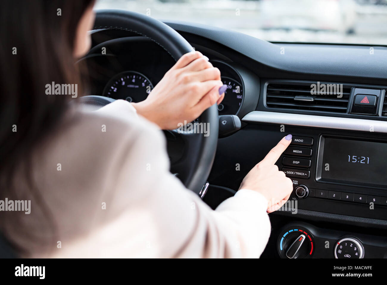 Woman pressing radio button on car's control panel Stock Photo - Alamy