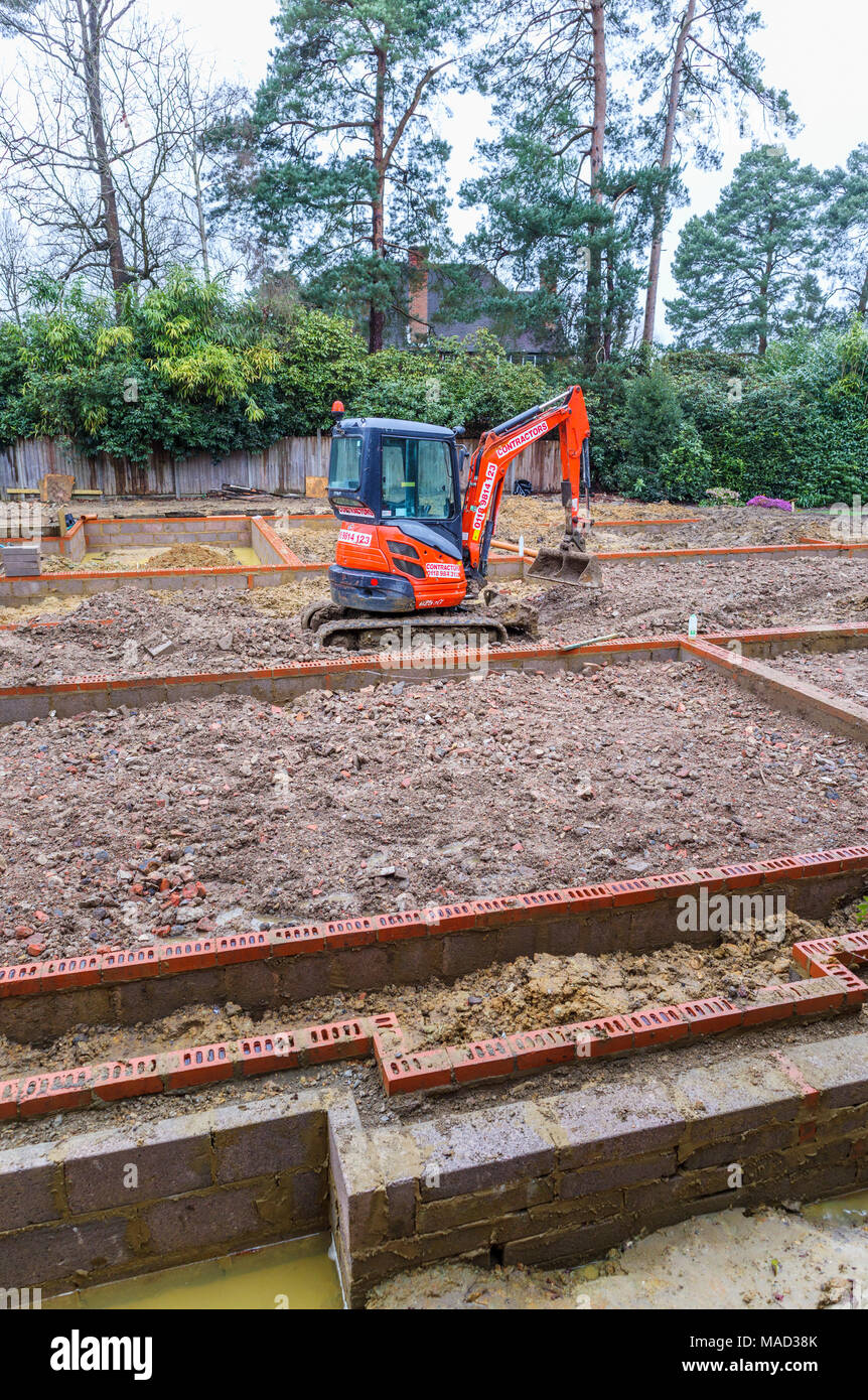 Orange Hitachi heavy plant mechanical digger in the foundations of a ...