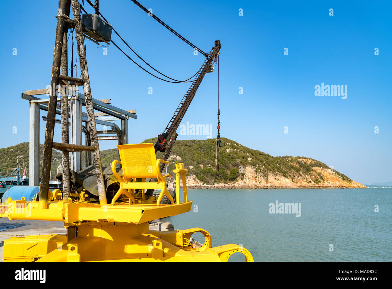 Fishing boat dock, crane against blue sky background Stock Photo - Alamy
