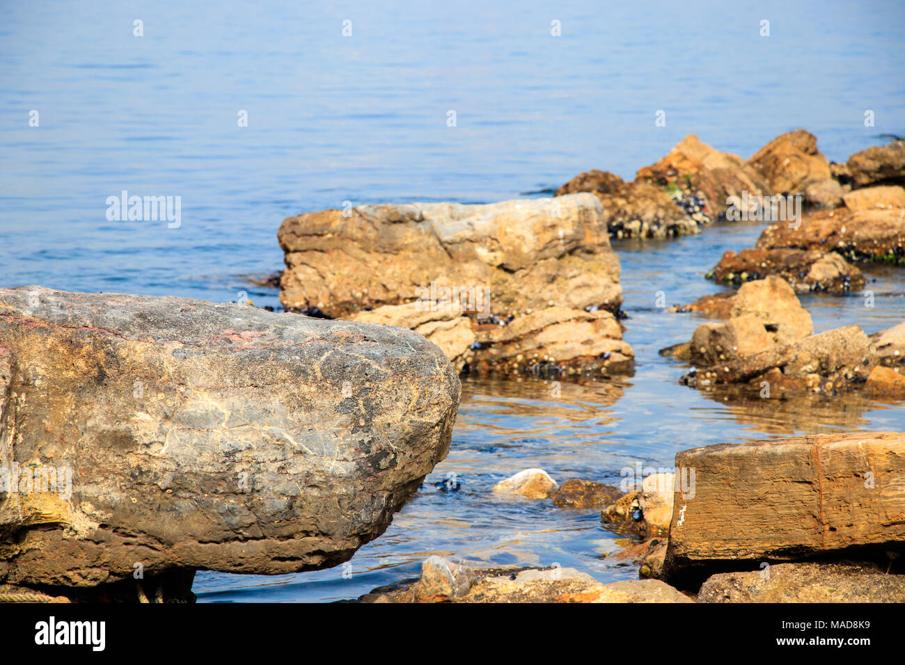 rock stone in blue sea nature background Stock Photo - Alamy
