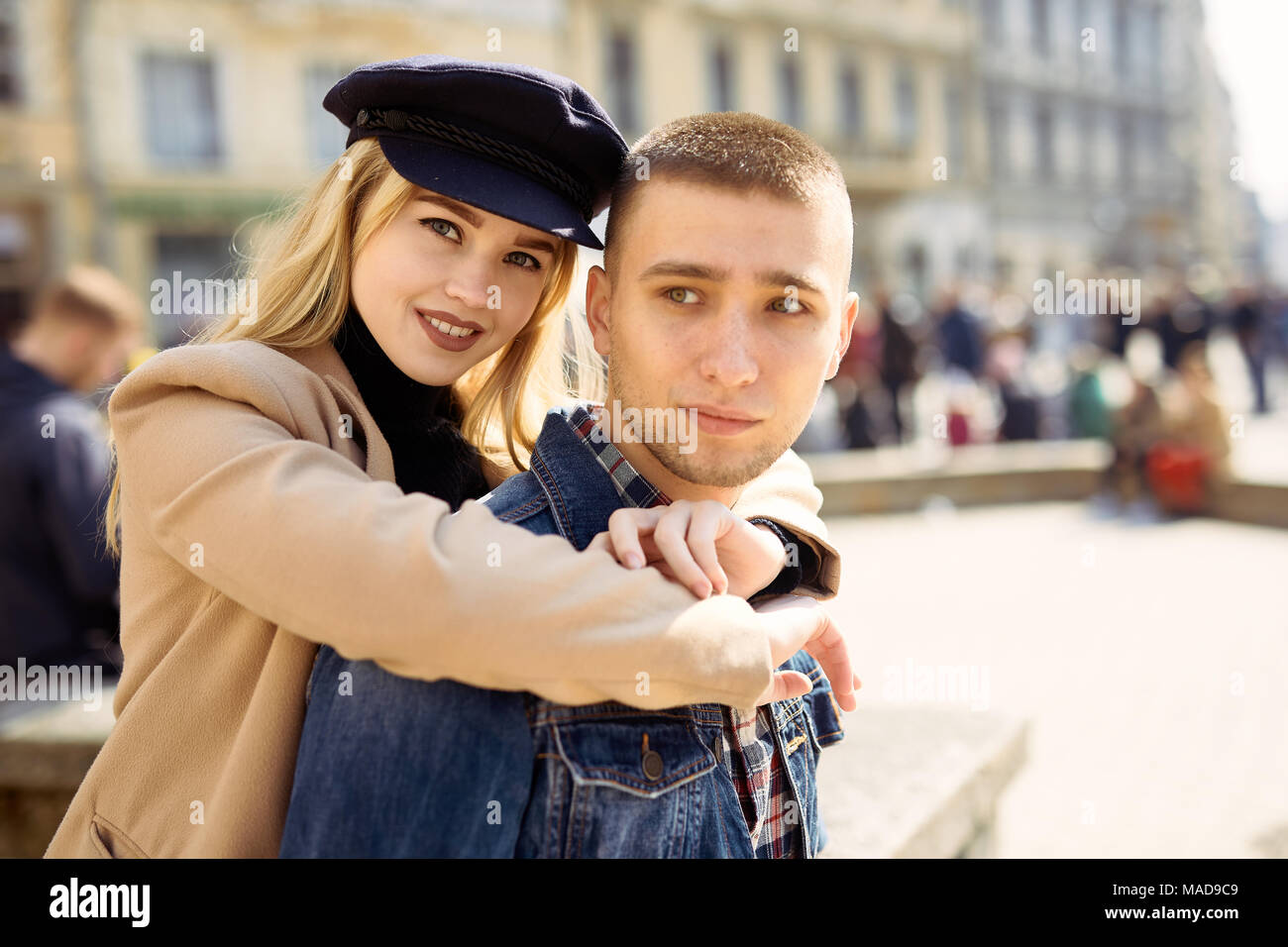 Lovely couple stand on city landscape and hug each other with sun on ...