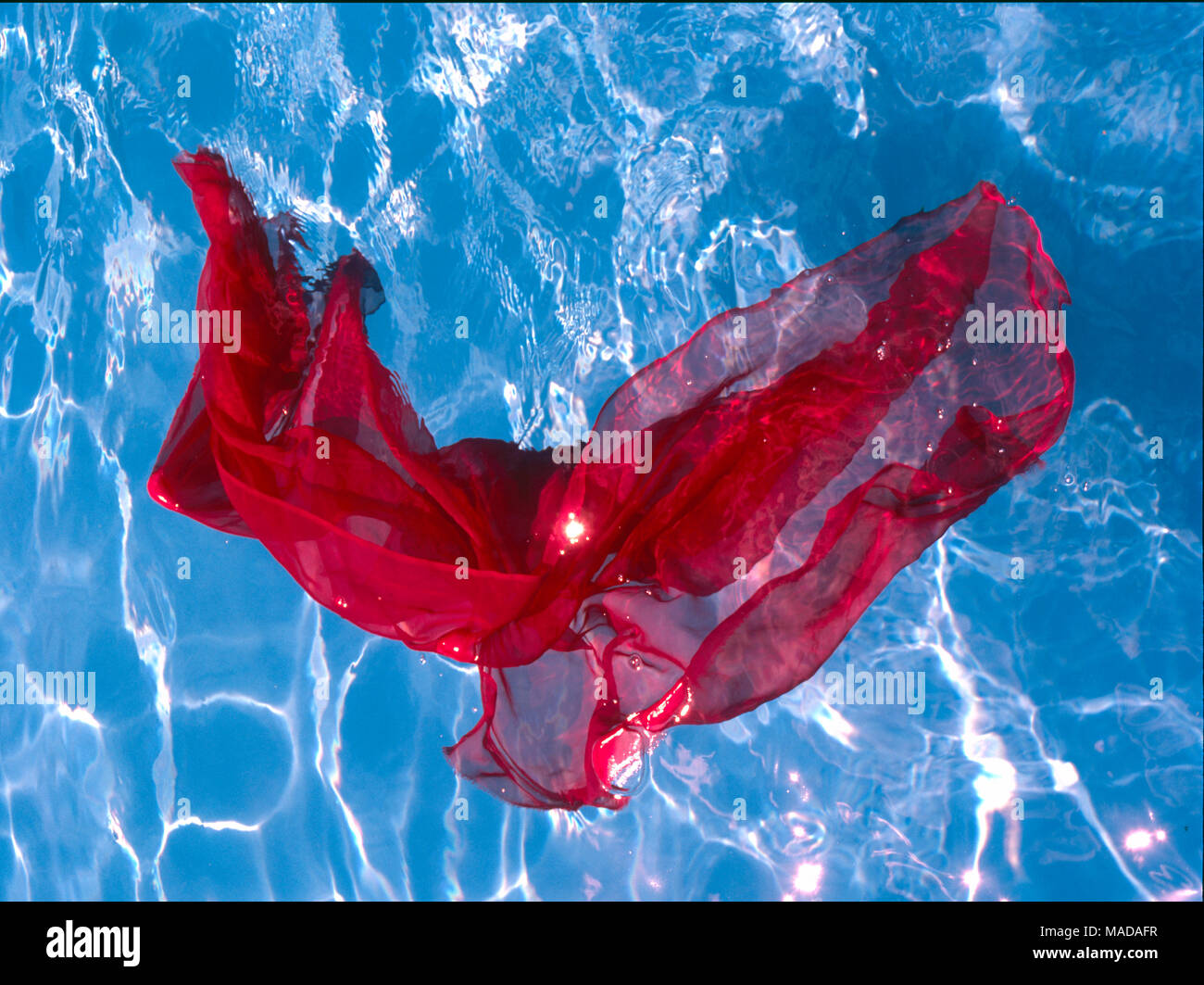 Red fabric floating in pool Stock Photo - Alamy