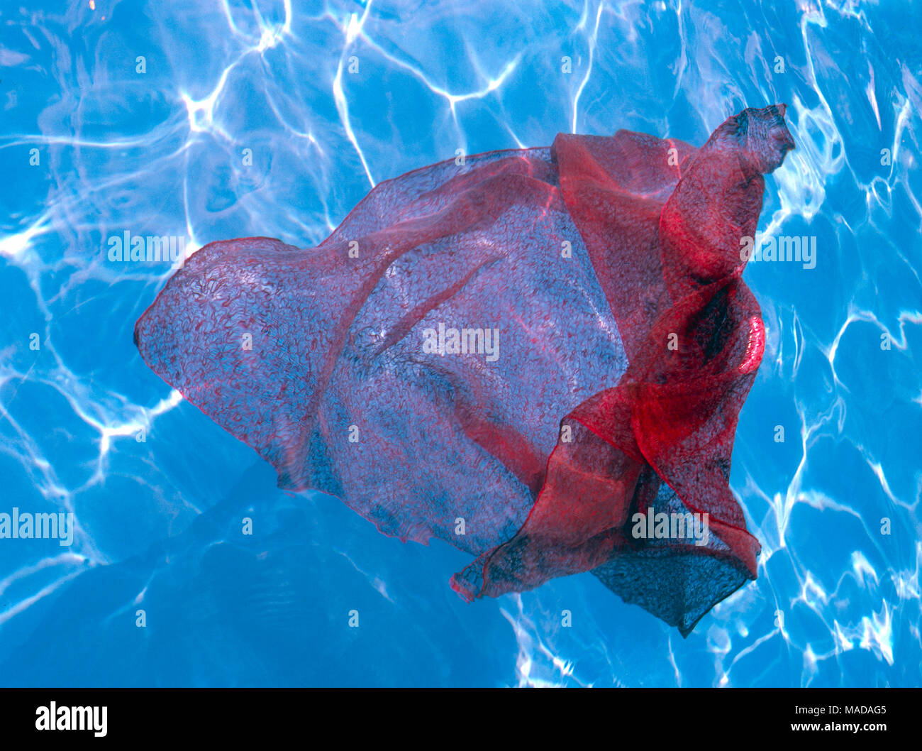 Red fabric floating in pool Stock Photo - Alamy