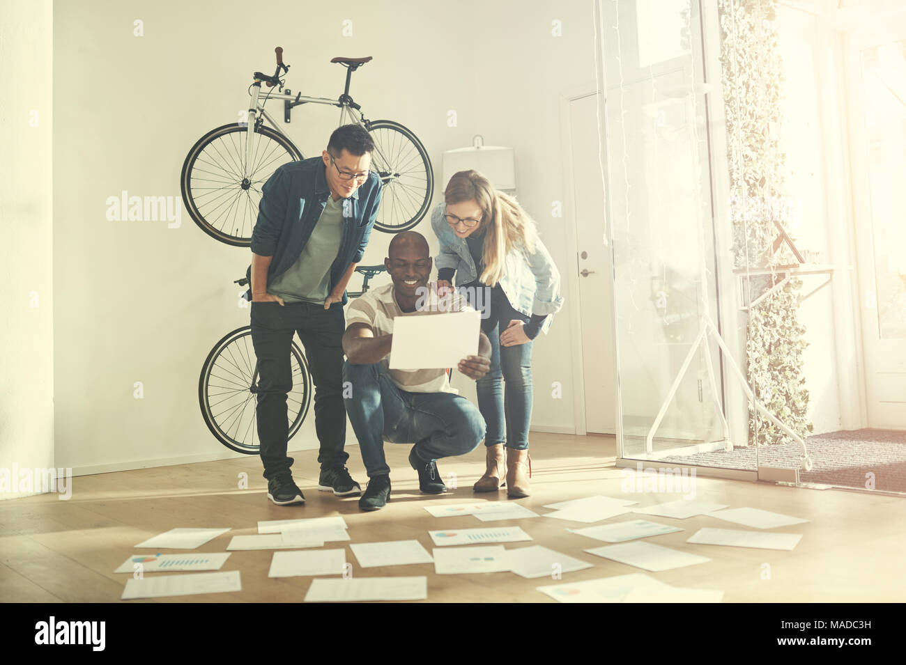 Smiling group of diverse colleagues standing in a stylish modern office ...