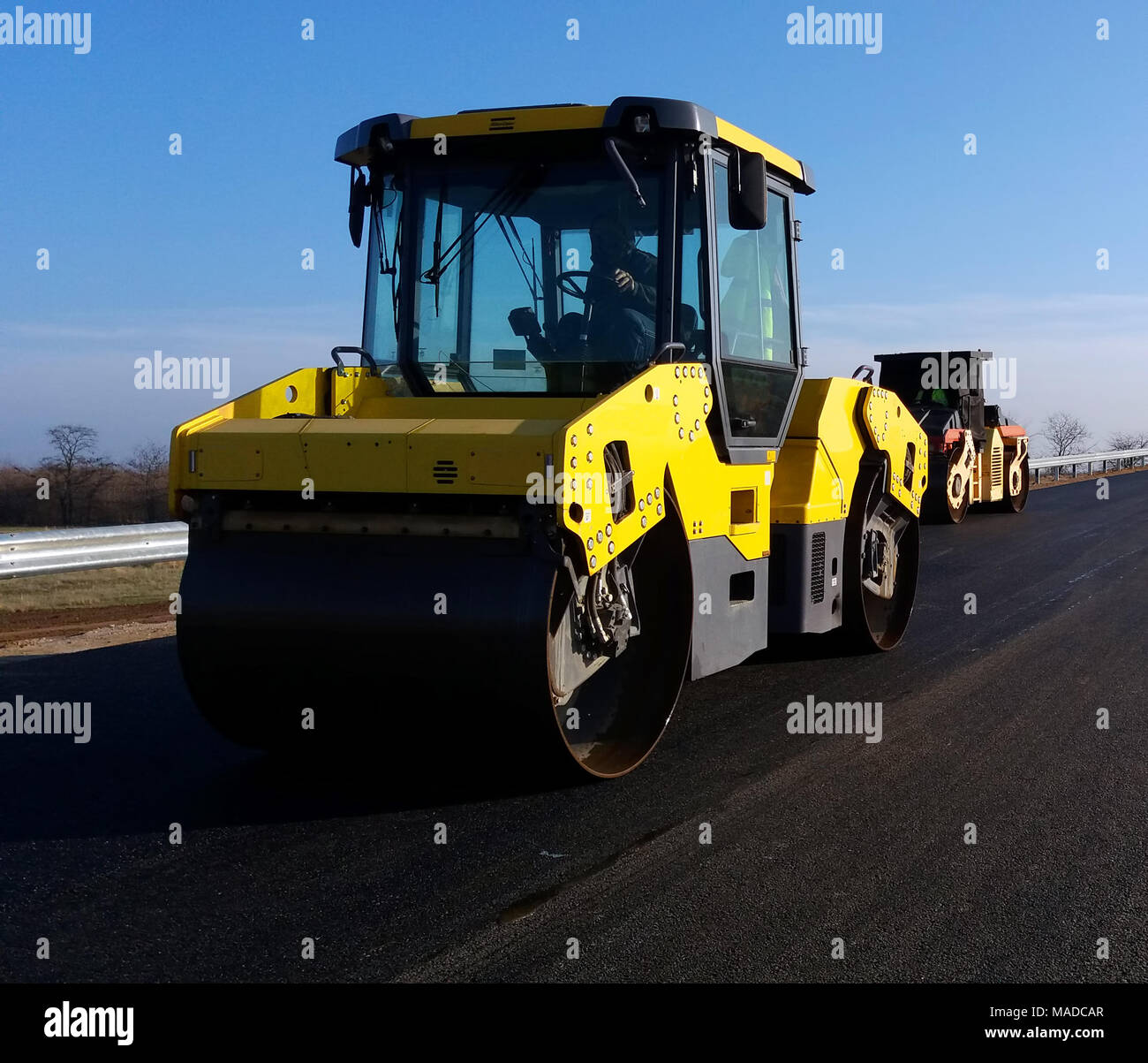 Two compactor pressing bitumen Stock Photo - Alamy