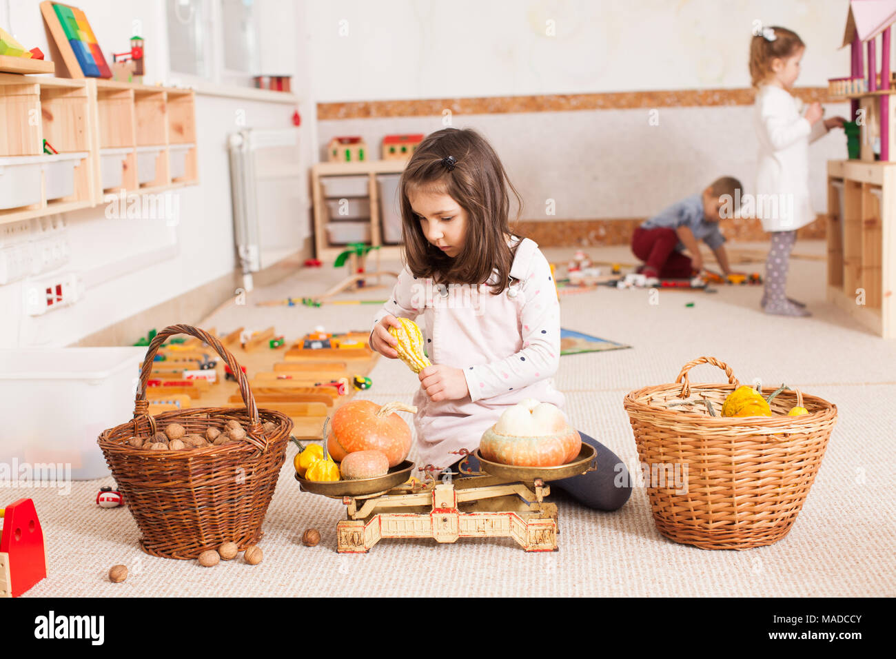 cute little girl is playing with scales Stock Photo - Alamy