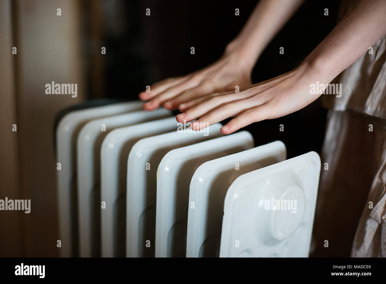 Hands over the radiator. Warm battery Stock Photo - Alamy