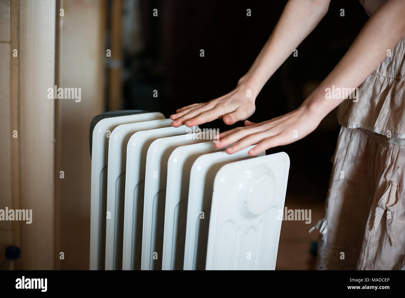 Hands over the radiator. Warm battery Stock Photo - Alamy