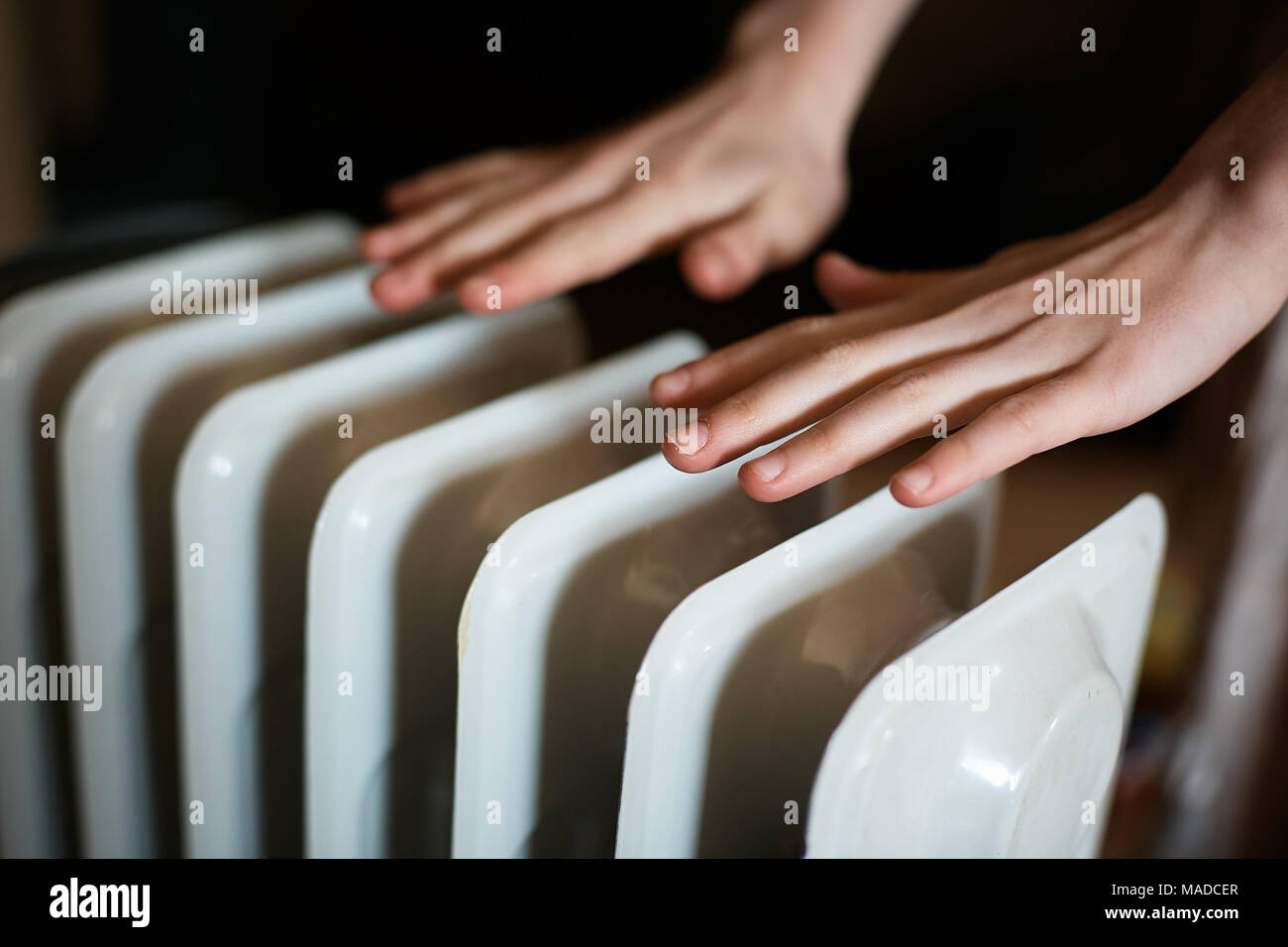 Hands over the radiator. Warm battery Stock Photo - Alamy