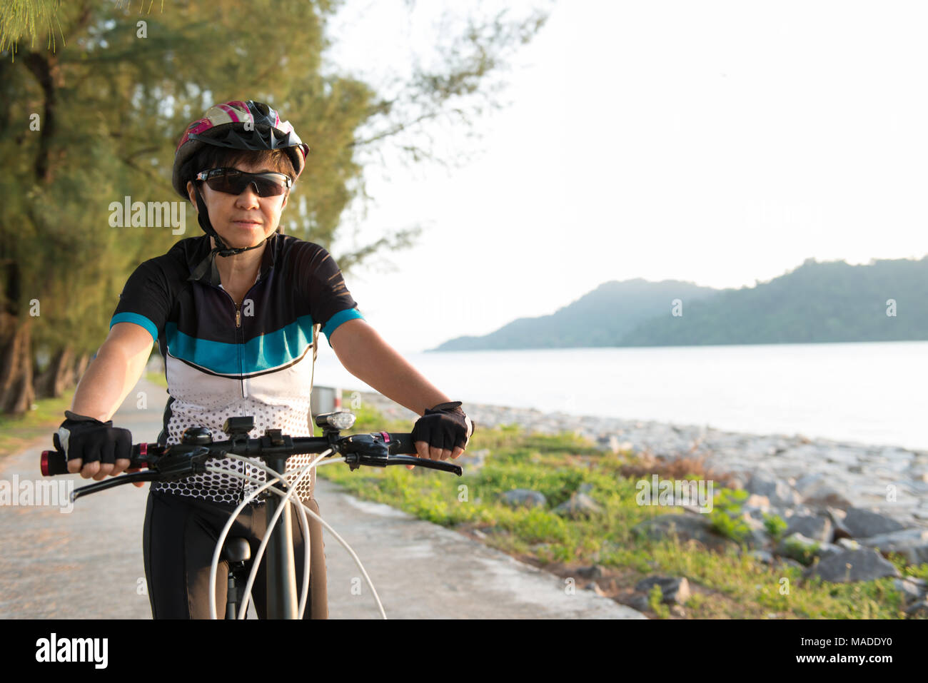 Older woman riding exercise bike hi-res stock photography and images ...
