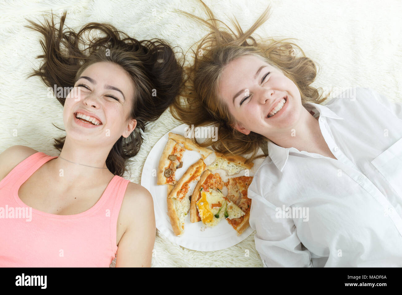 overeat happy girls lying on bed eats pizza, laughing Stock Photo - Alamy