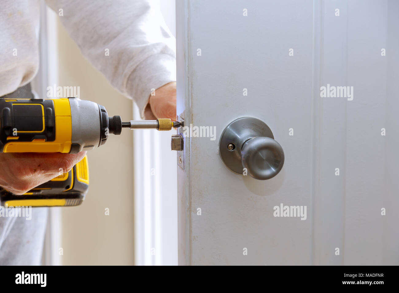 installation of locks on the door Hands repairing a door lock with a ...