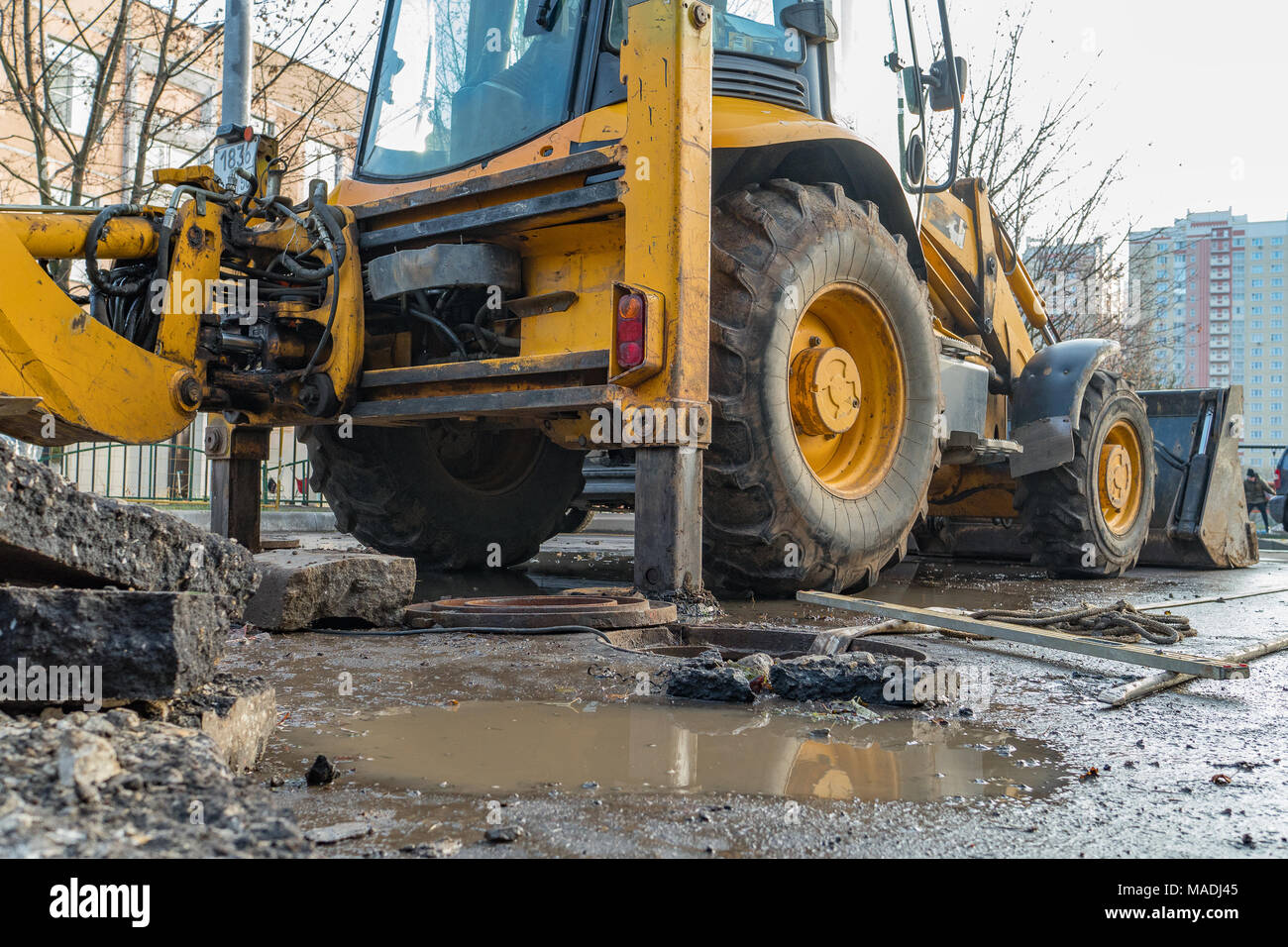 Workers excavate the pit with an excavator. Road repair. Pipeline ...