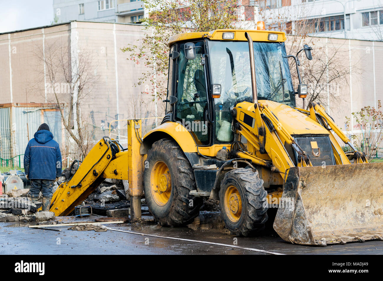 Workers excavate the pit with an excavator. Road repair. Pipeline ...