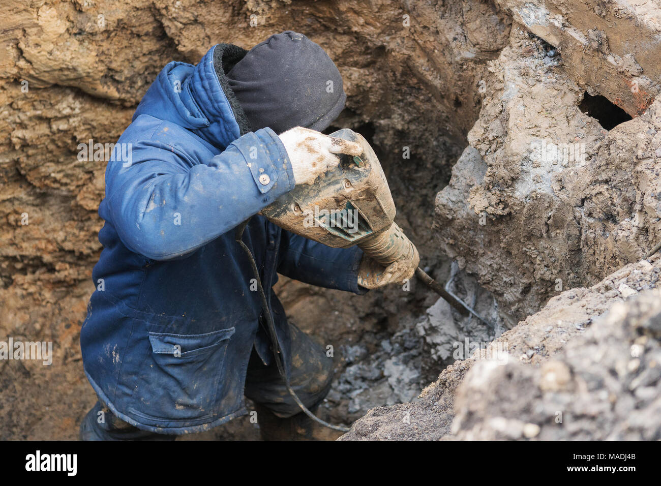 Workers excavate the pit with an excavator. Road repair. Pipeline ...