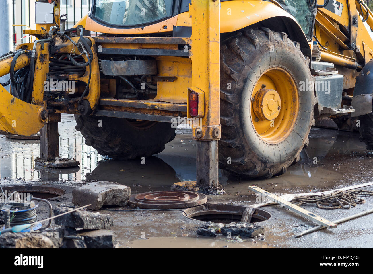 Workers excavate the pit with an excavator. Road repair. Pipeline ...