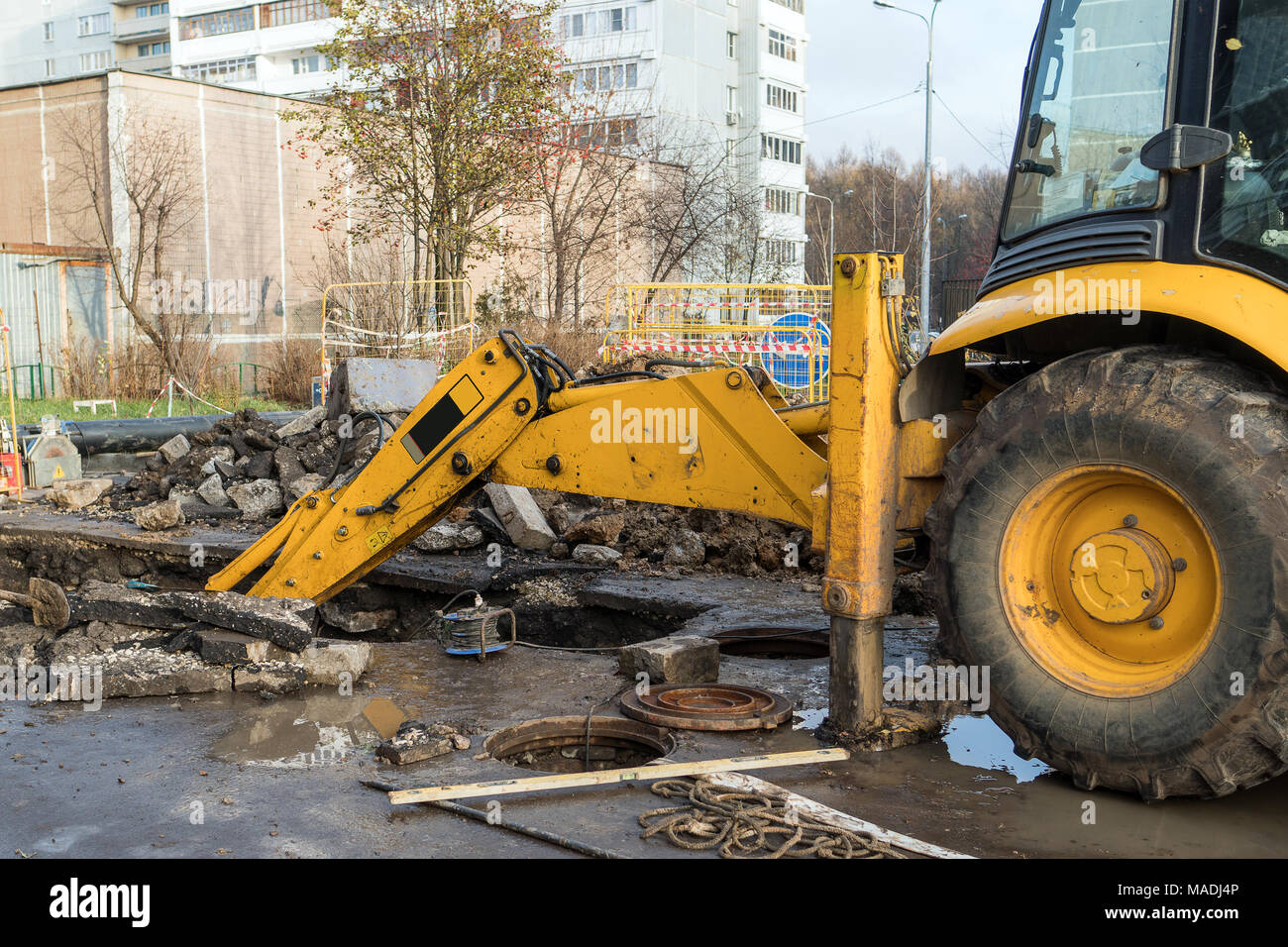 Workers excavate the pit with an excavator. Road repair. Pipeline ...