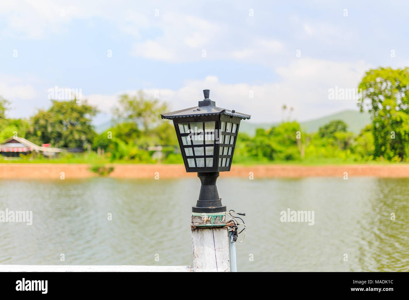 old lamp post on fence beside the pond Stock Photo - Alamy