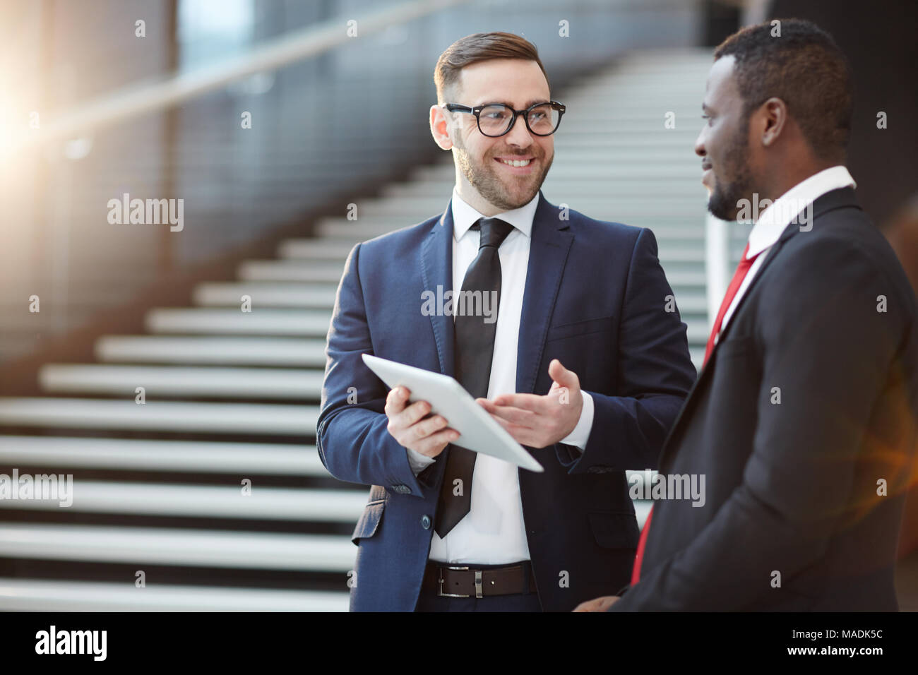 Successful delegate in elegant suit showing online data to his ...