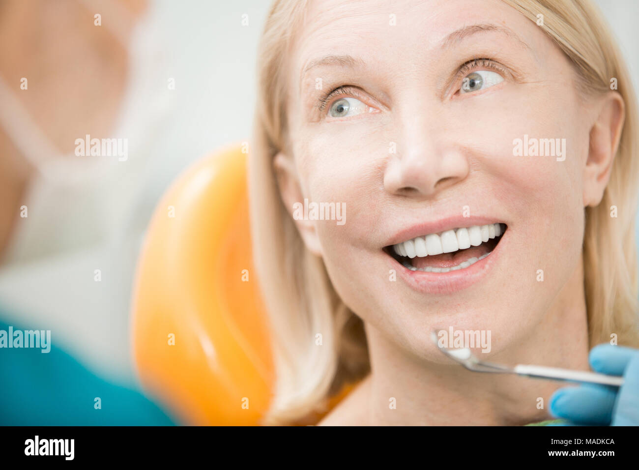 Happy patient with healthy teeth looking at dentist before check-up of oral cavity Stock Photo ...