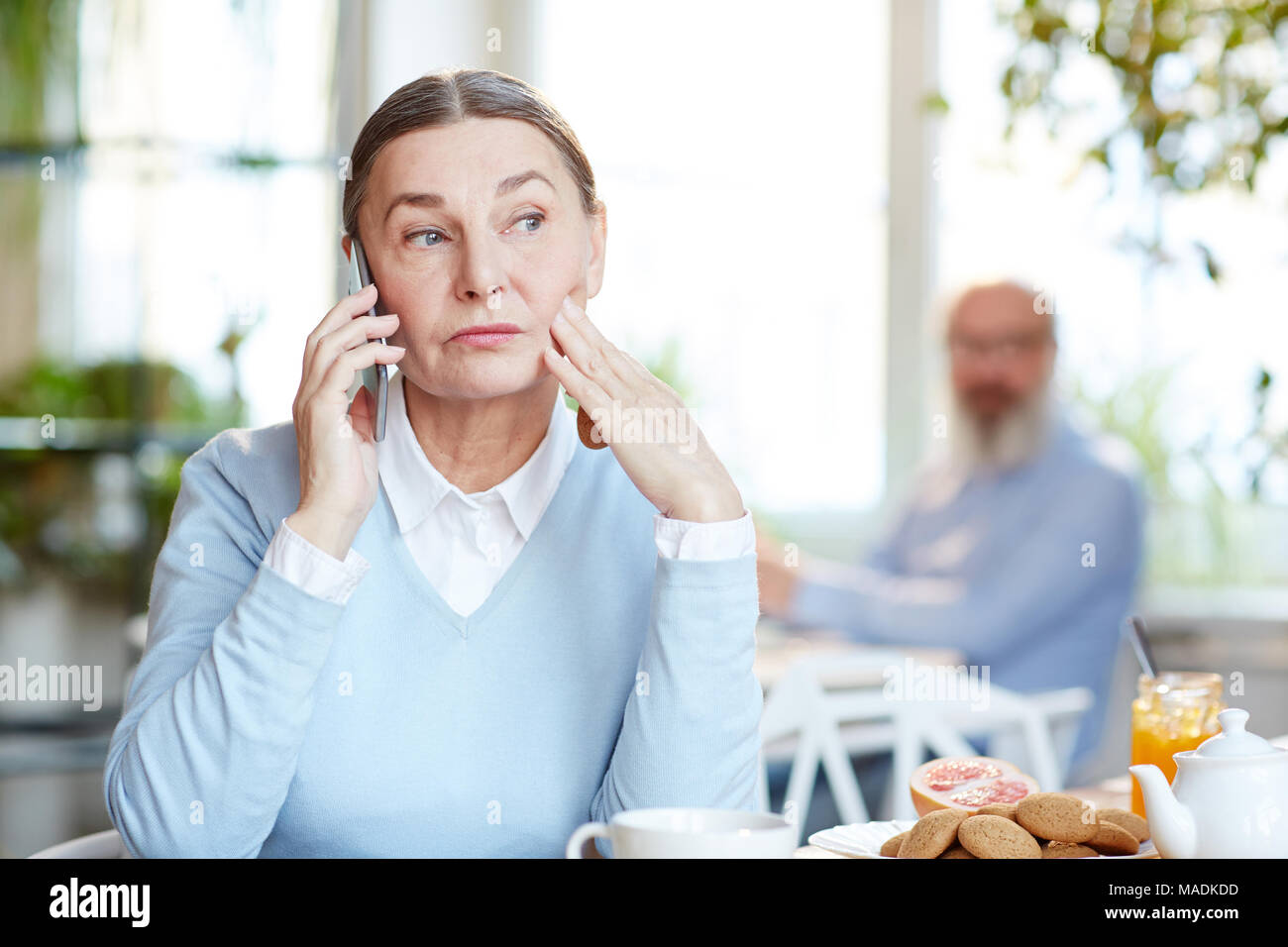 Distracted senior sitting at table hi-res stock photography and images - Alamy