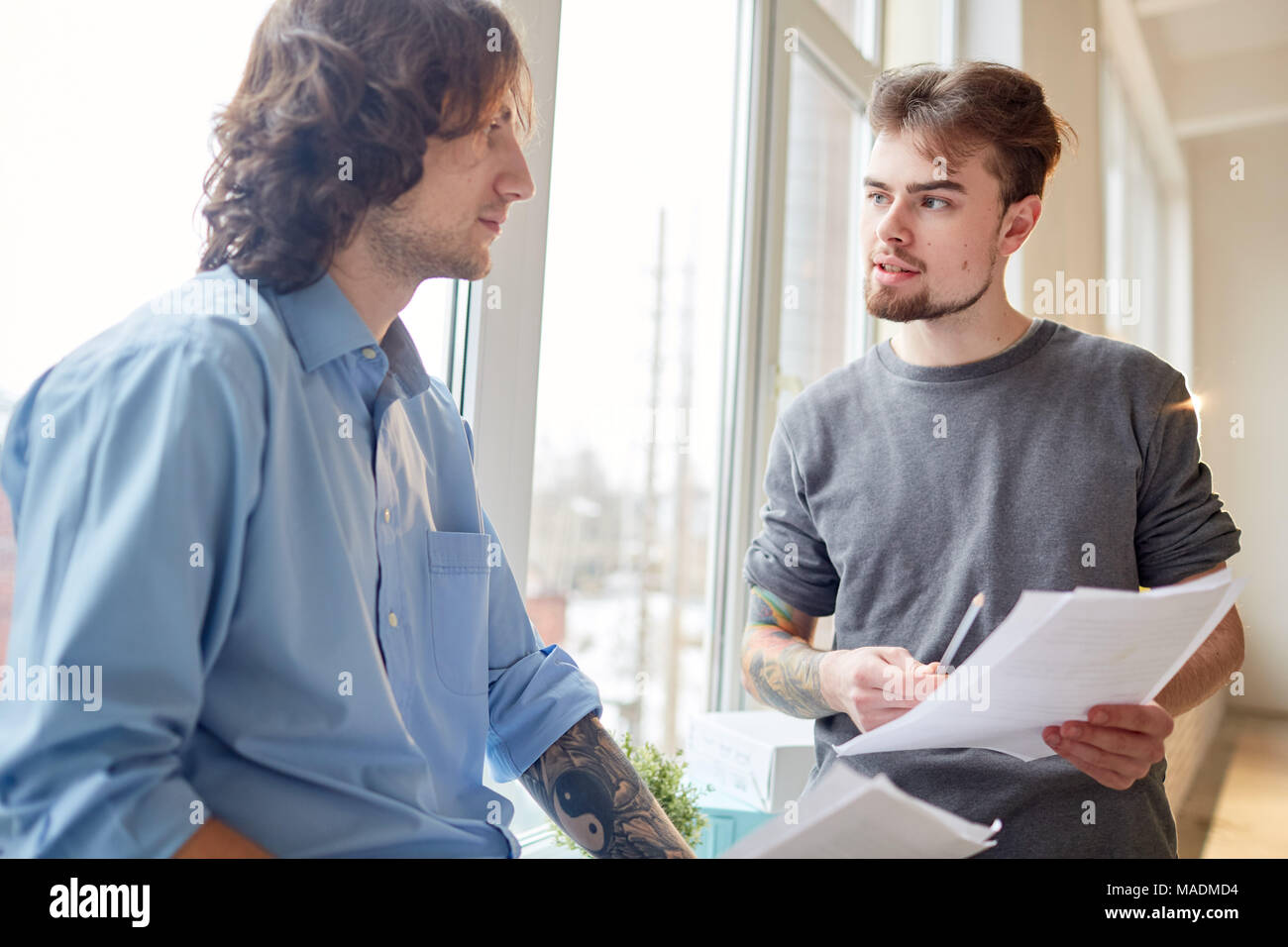 Two coworkers discussing financial report together in team Stock Photo ...