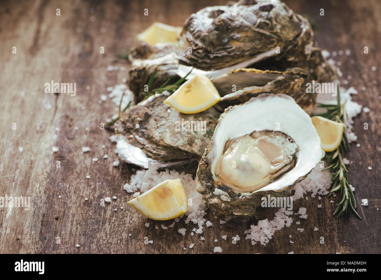 A photo of freshly opened oysters on a wooden background texture with ...