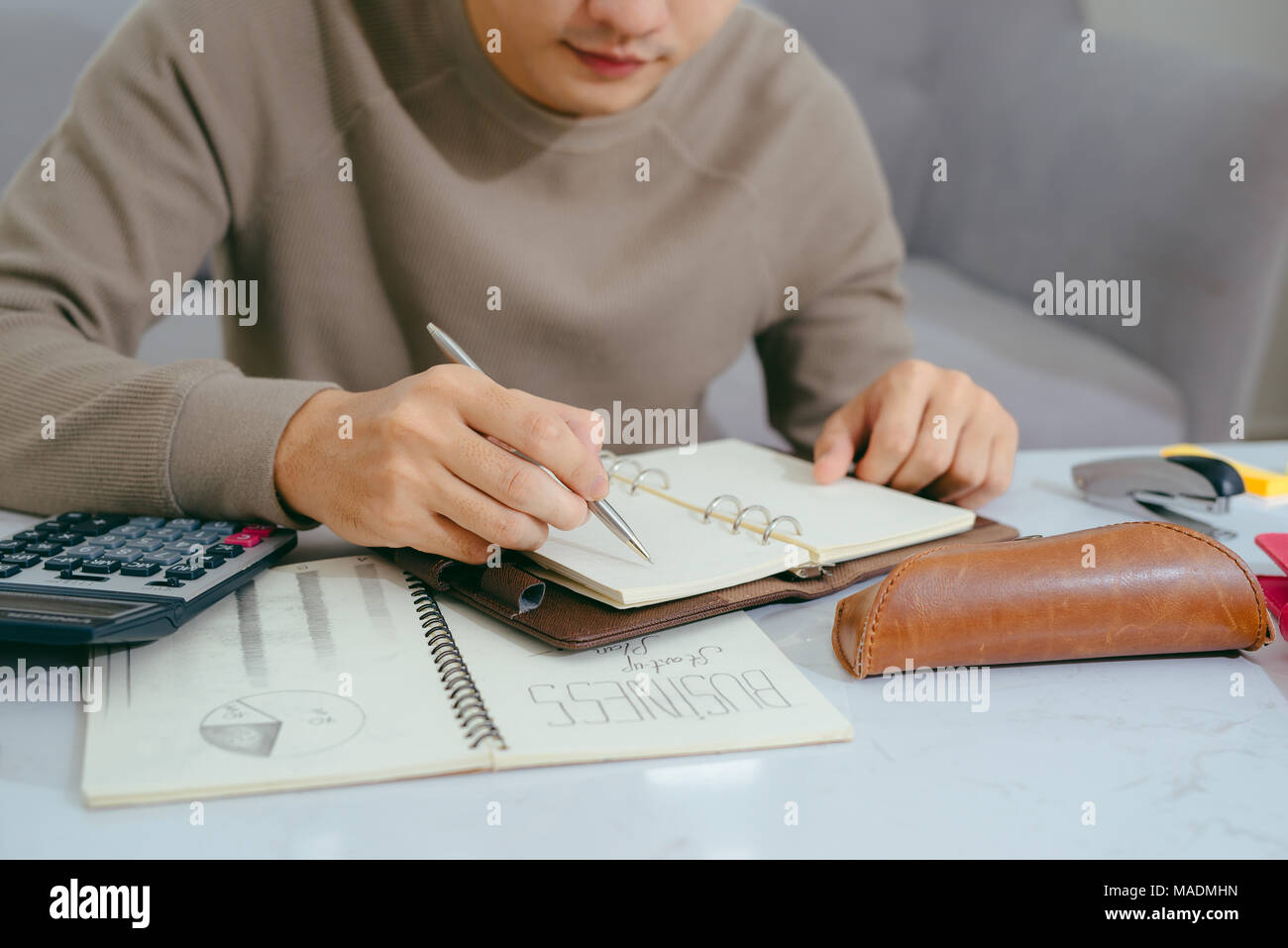 Focused Asian man paying his bills in the living room Stock Photo - Alamy