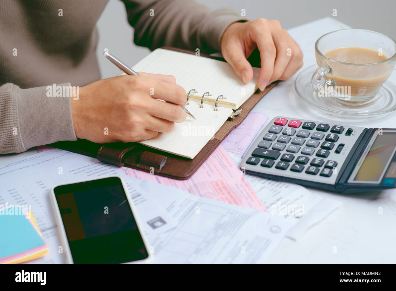 Stressed asian man working through paperwork, calculating expenses ...