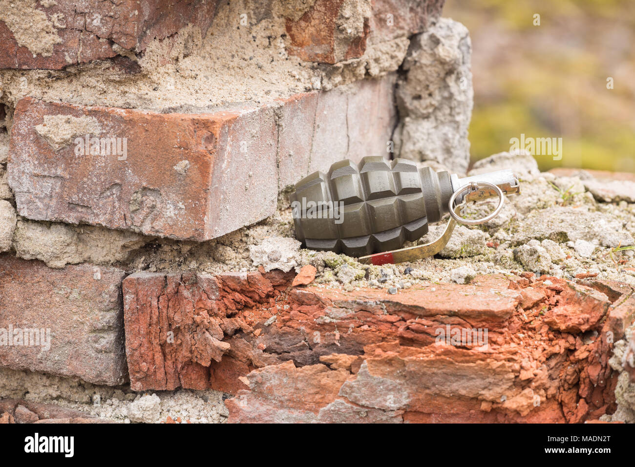 Hand grenade lying on a brick wall Stock Photo - Alamy