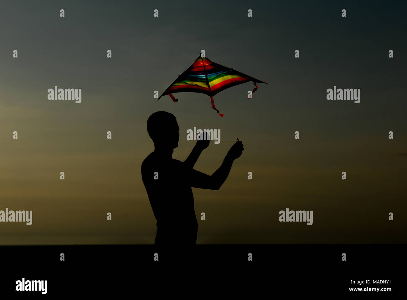 Silhouette of person flying kite hi-res stock photography and images ...