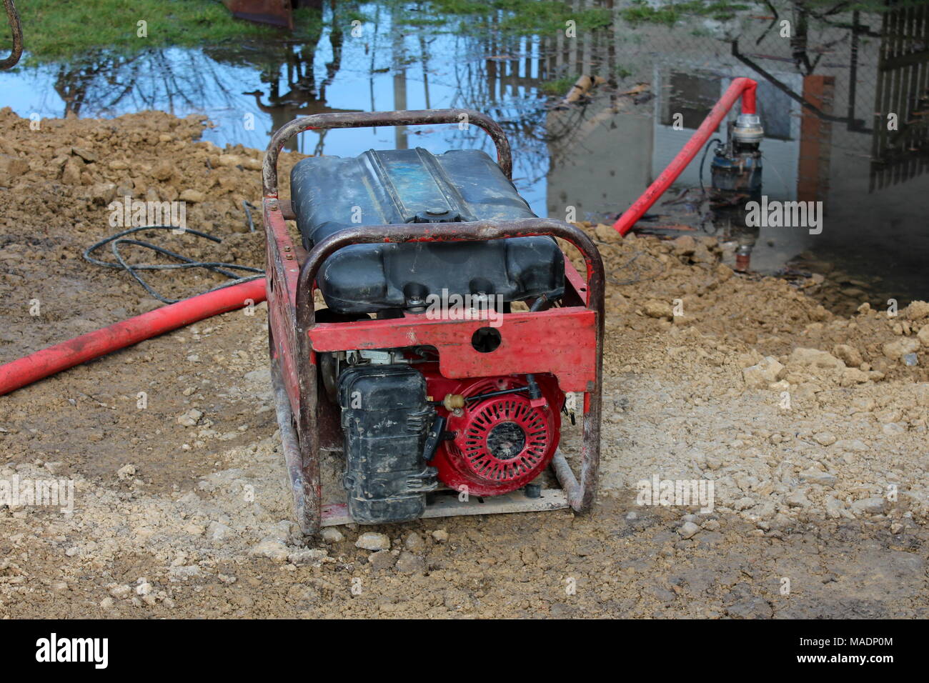 Petrol water pump with hard metal frame pumping water from side of the ...