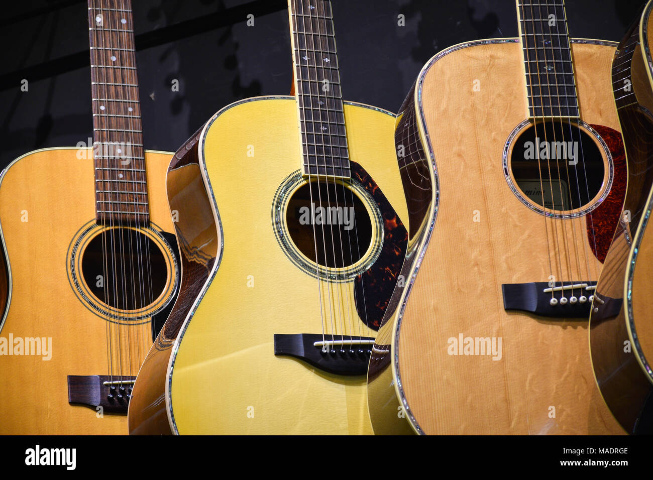 Three acoustic guitars hanging in a generic retail shop Stock Photo - Alamy