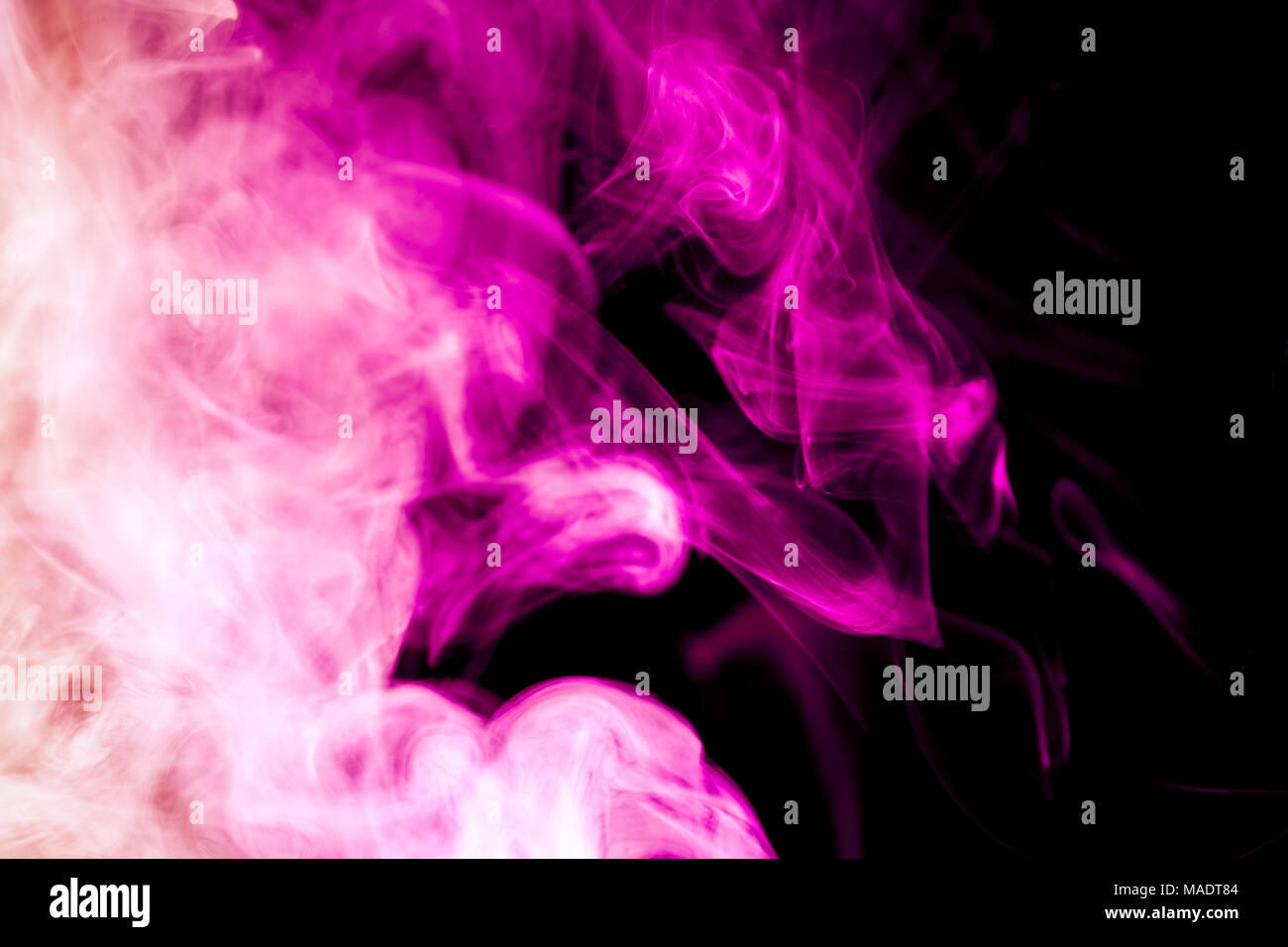 Colorful pink smoke on a black isolated background. Background from the ...