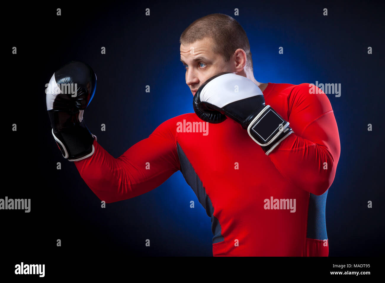 A strong dark-haired sportman boxer in a red sports wear rush guard and ...