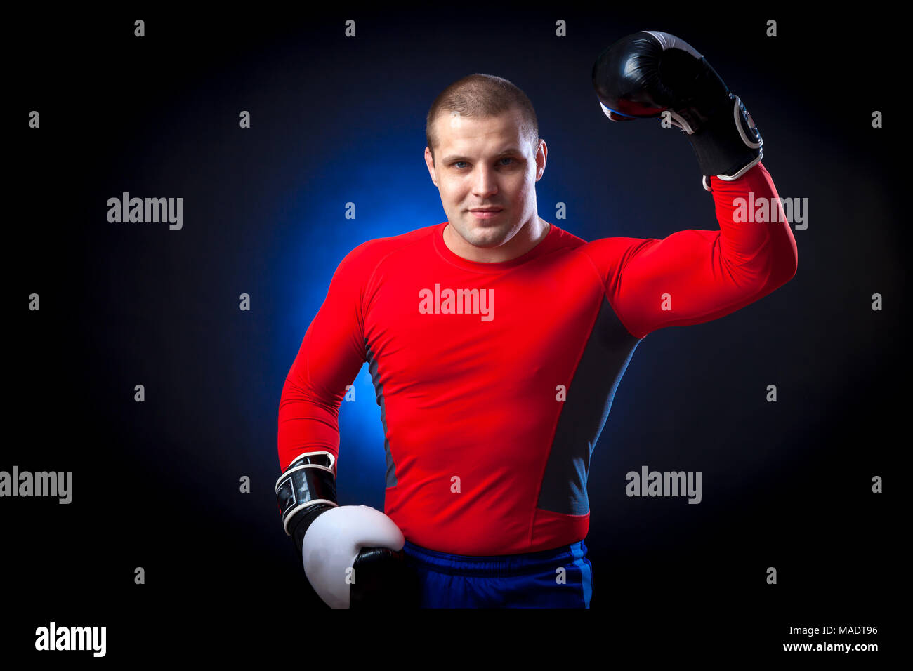 A strong dark-haired sportman boxer in a red sports wear rush guard and ...